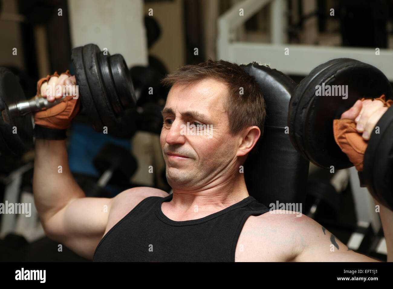 training dumbbells in gym. Male lifting weights for upper body strength ...