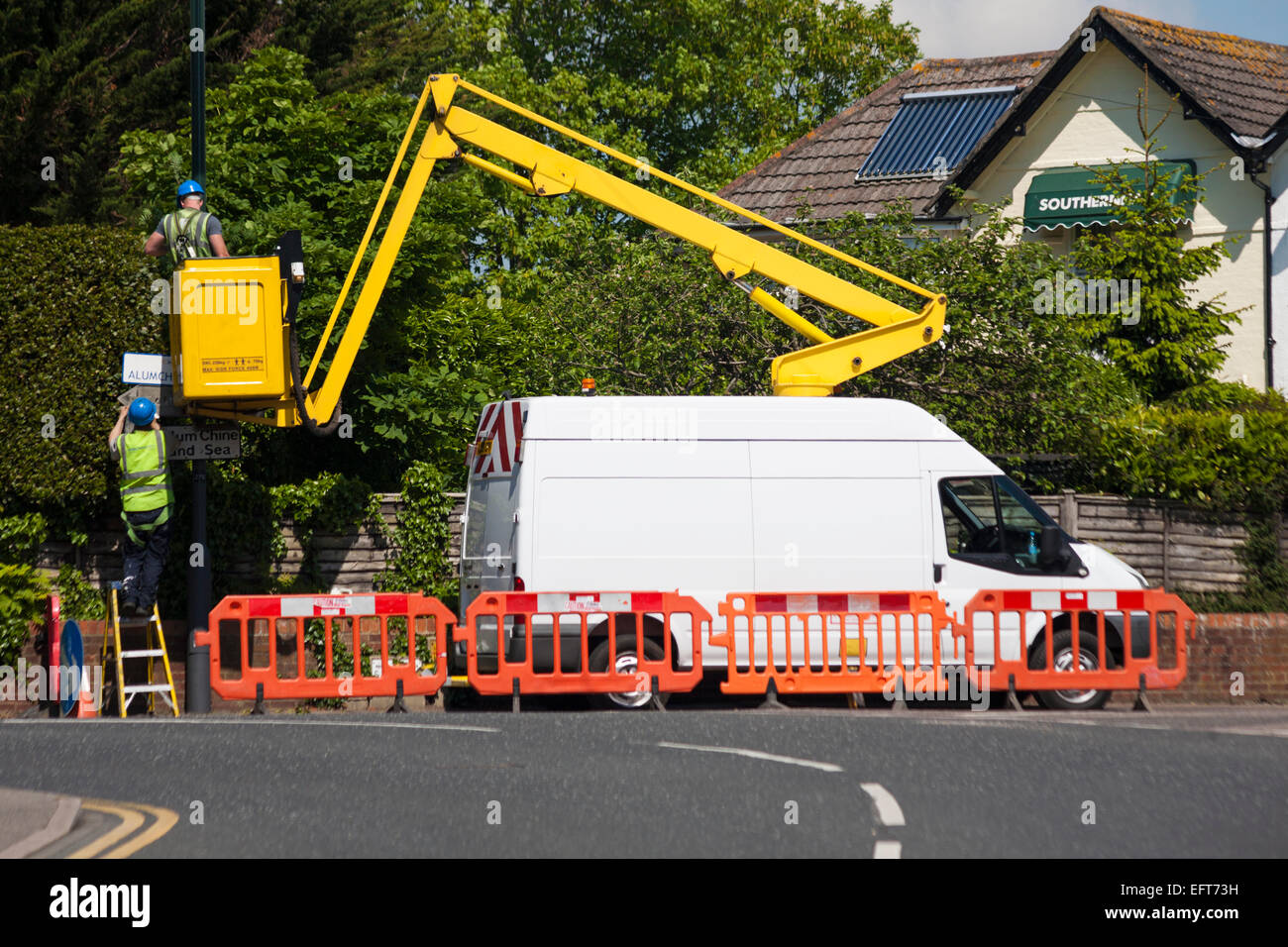 Workmen cleaning dirty road signs at Westbourne, Bournemouth in May ...