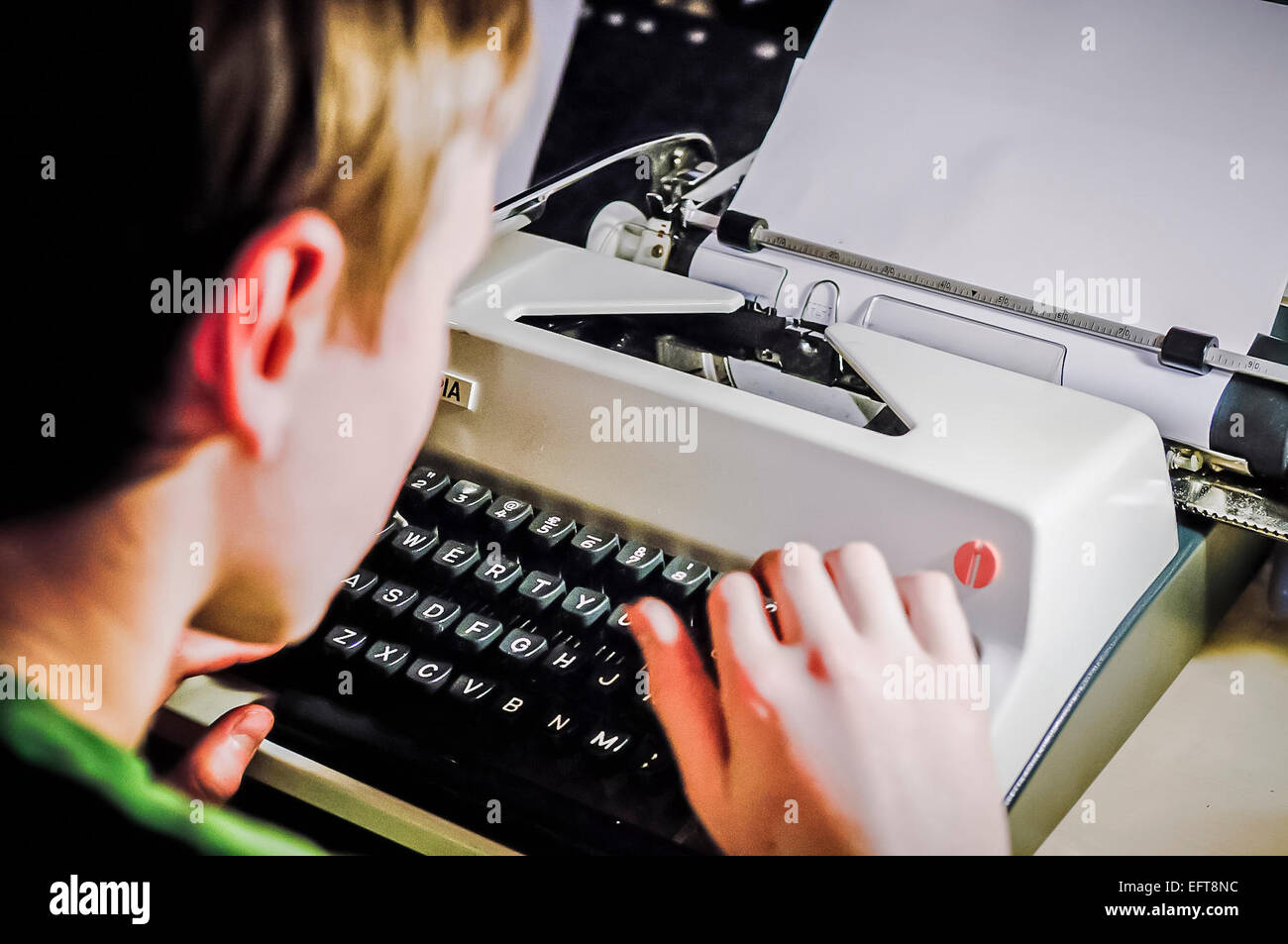 Boy types on an old fashioned mechanical typerighter Stock Photo - Alamy
