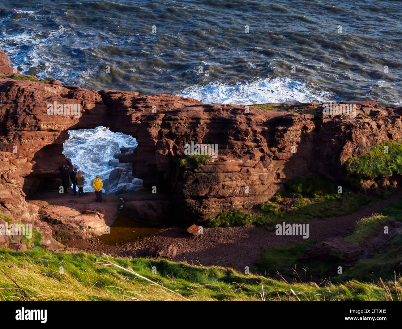 Wide shot of people at rock arch well known as Needle E'e on Seaton ...