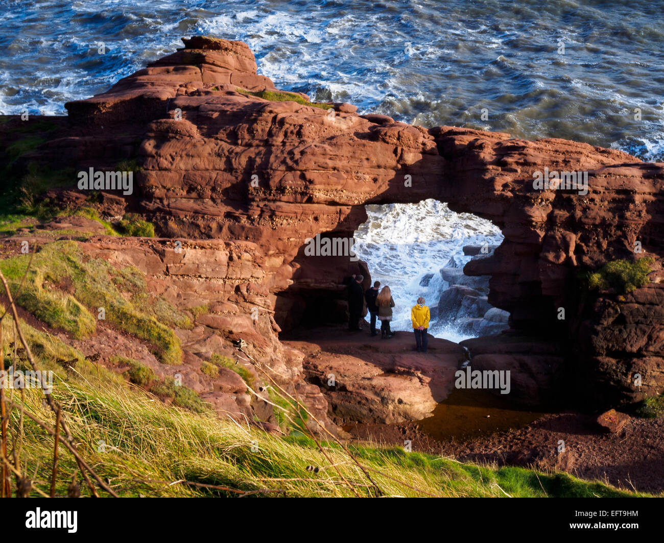 People viewing tidal waves from the North Sea crash against rocks at ...