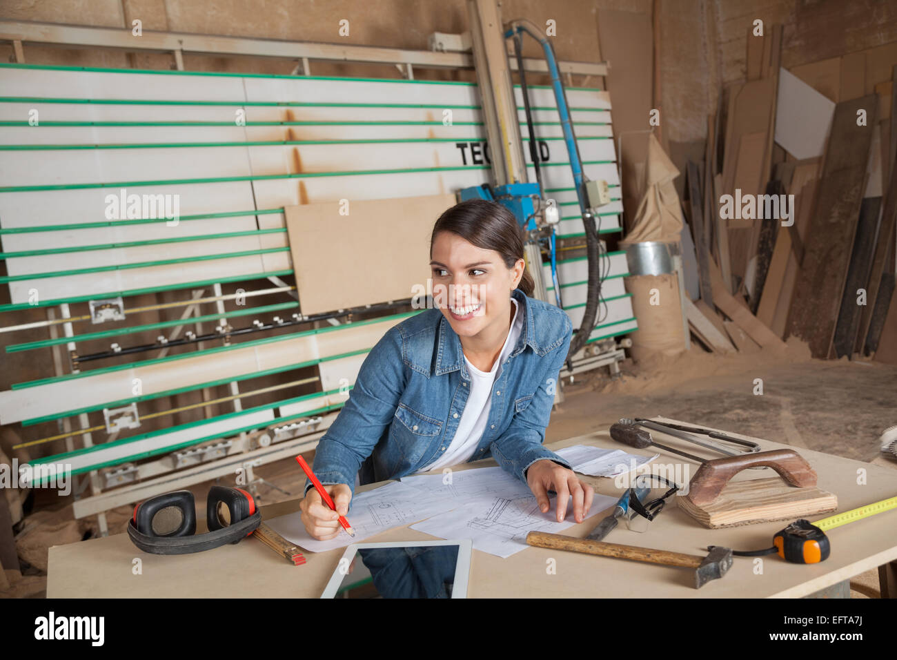 Carpenter Working On Blueprint While Looking Away Stock Photo - Alamy
