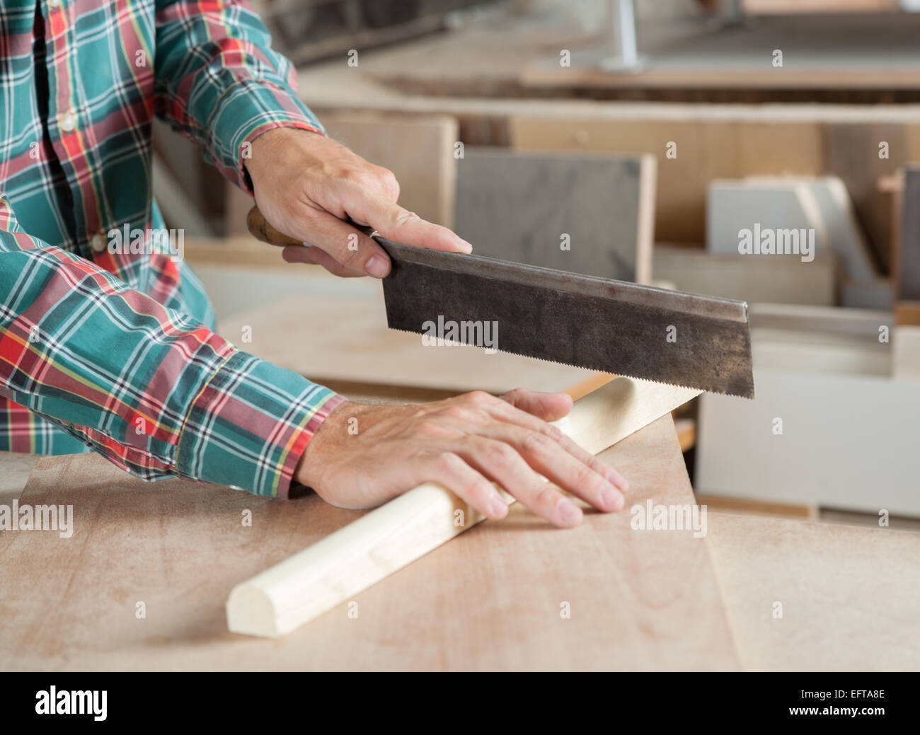 Carpenter's hand using small saw to cut wood in workshop Stock Photo ...