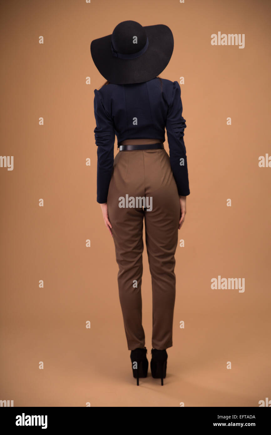 Back view portrait of a fashion woman over brown background Stock Photo ...
