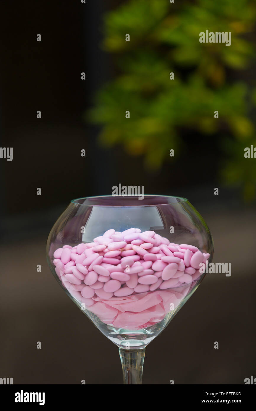 Pink color sugar almonds in a transparent bowl Stock Photo - Alamy