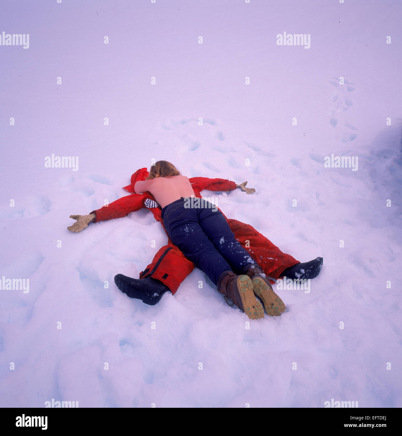 Female topless lying on her snowsuit in the snow on a Glacier, Iceland ...