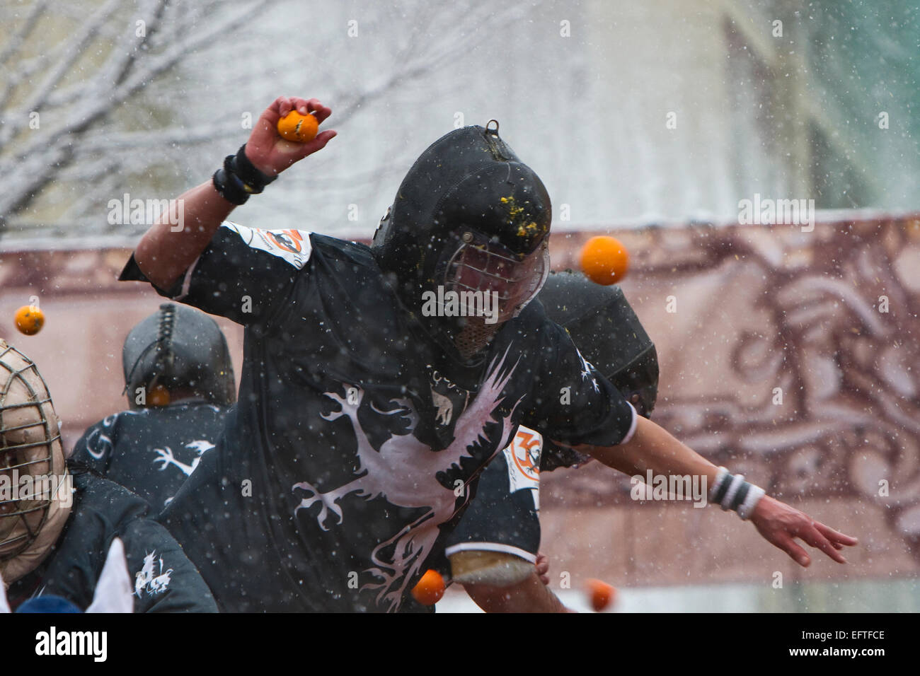 An orange thrower fighting from a cart during a snowfall as part of the ...