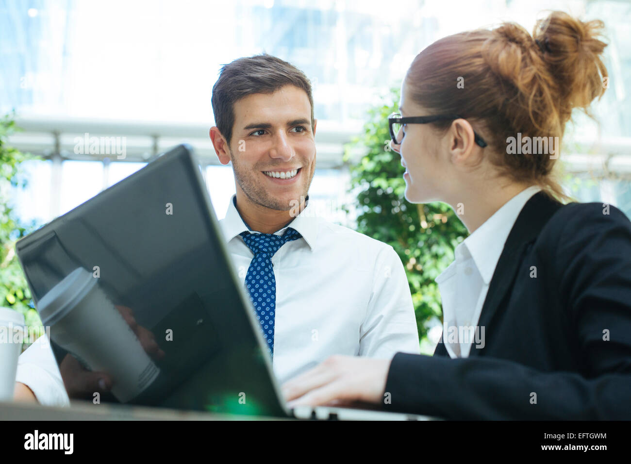 Two business people looking at laptop hi-res stock photography and ...