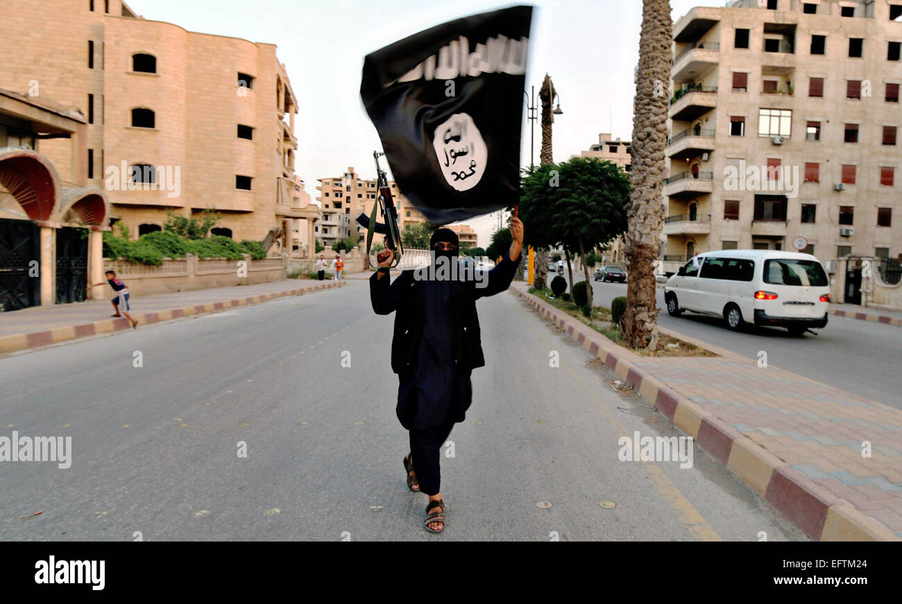 Islamic State of Iraq and the Levant fighter waves a Black flag during ...