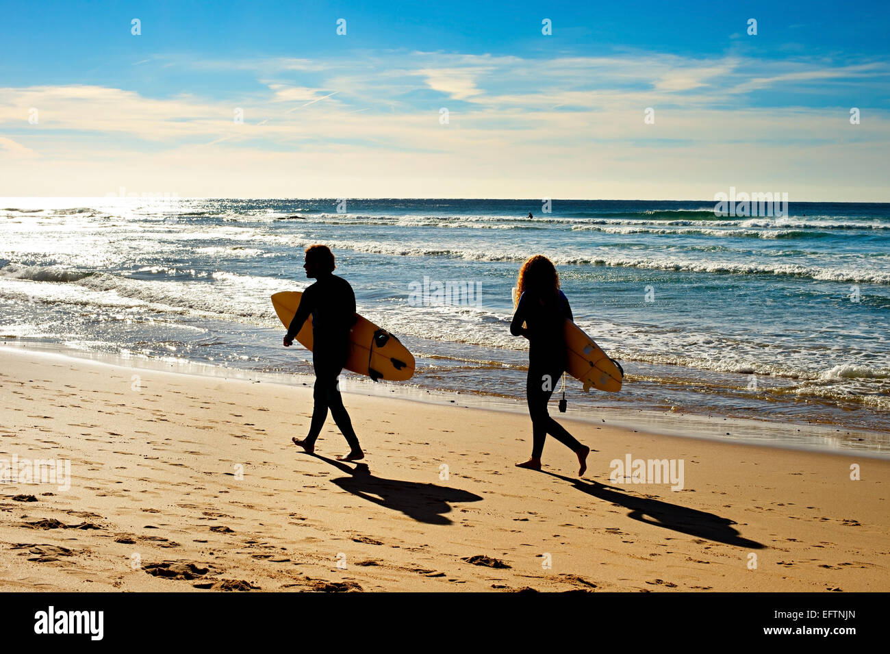 Couple walking with surfboard on beach hi-res stock photography and ...