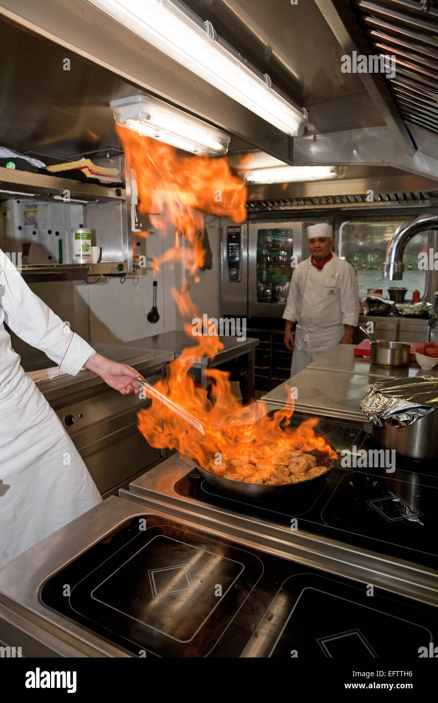 High flames as a chef flambès prawns Stock Photo - Alamy