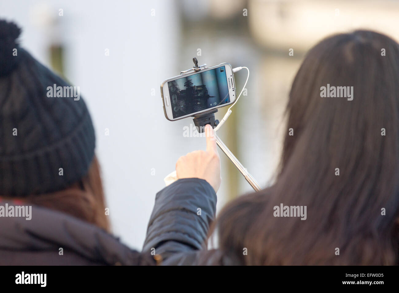 Take selfies using selfie sticks hi-res stock photography and images ...