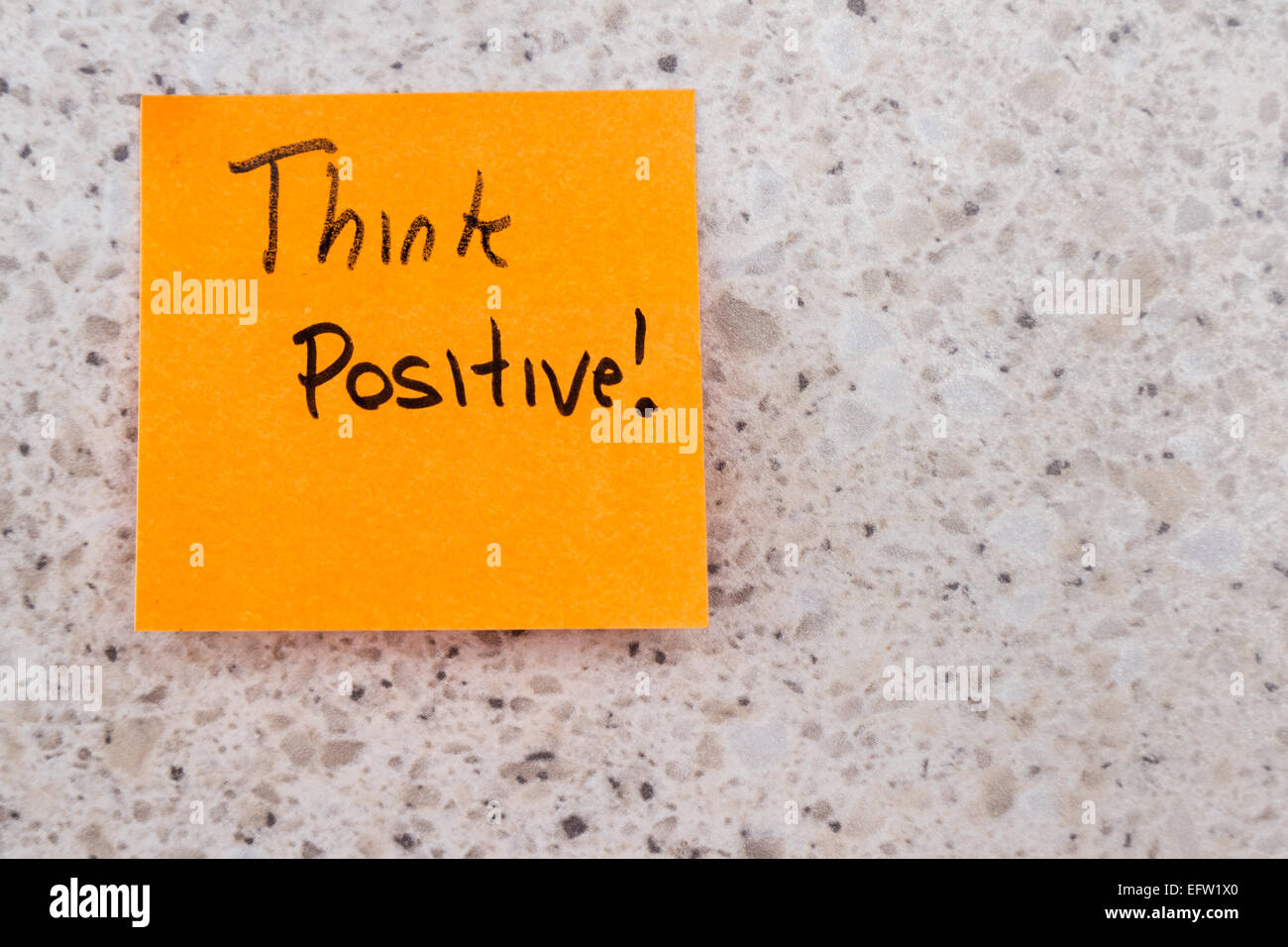 sticky note with a think positive message written on it on an office ...