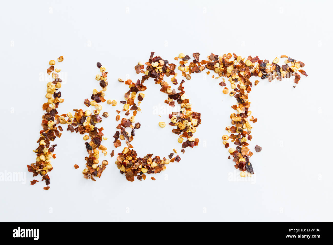 close up of red pepper flakes on a white background spelling the word ...