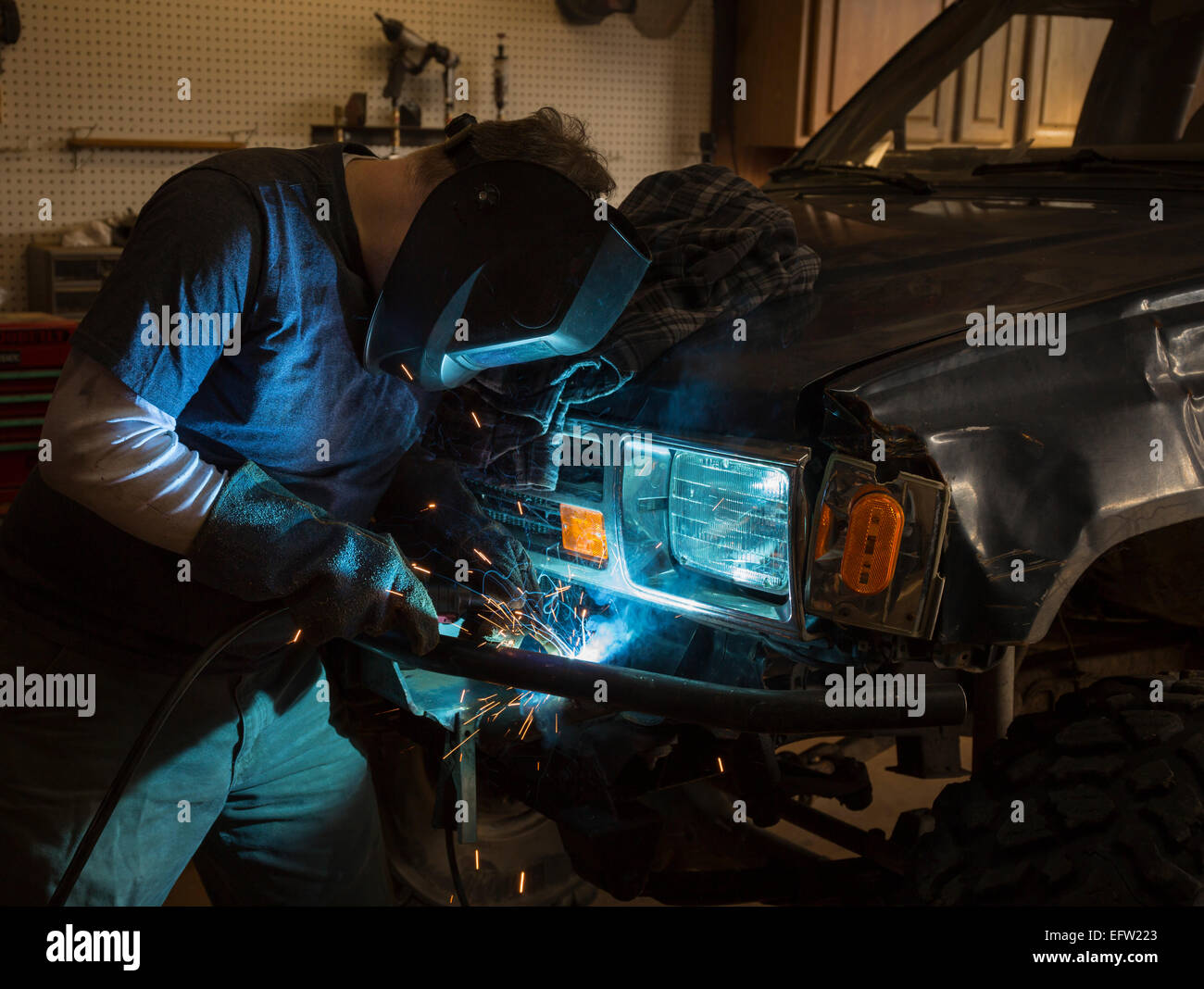 Man wearing welding helmet and welding the bumper of a vehicle Stock ...