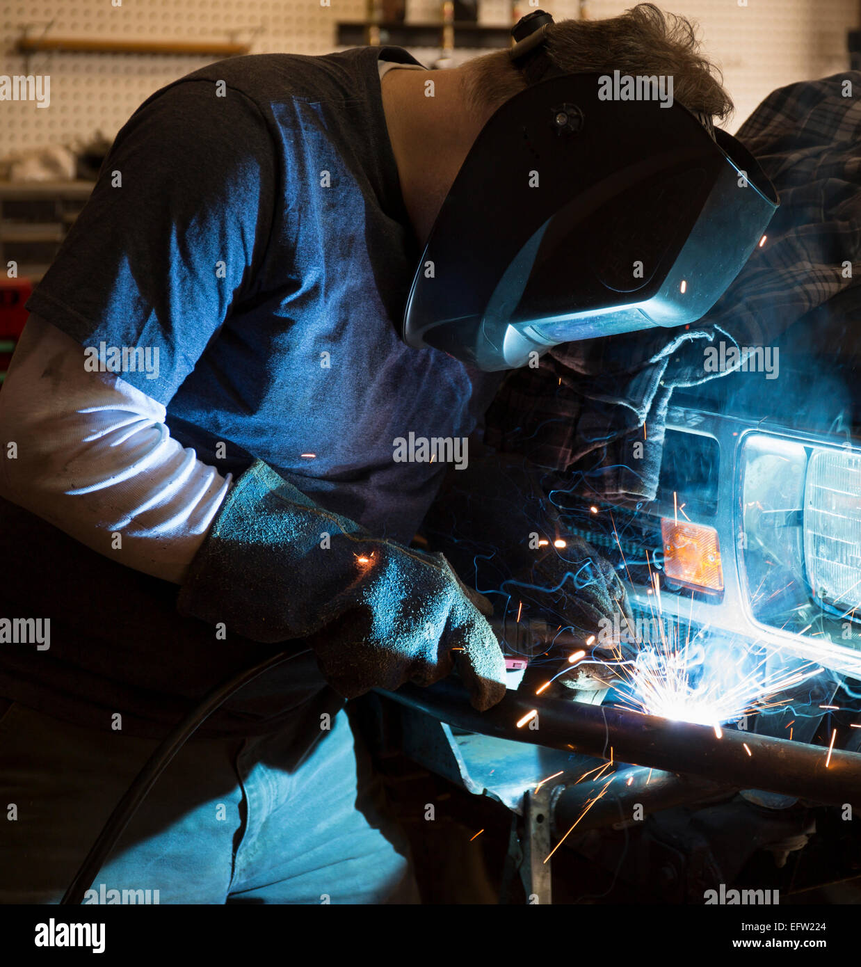 Man wearing welding helmet and welding the bumper of a vehicle Stock ...