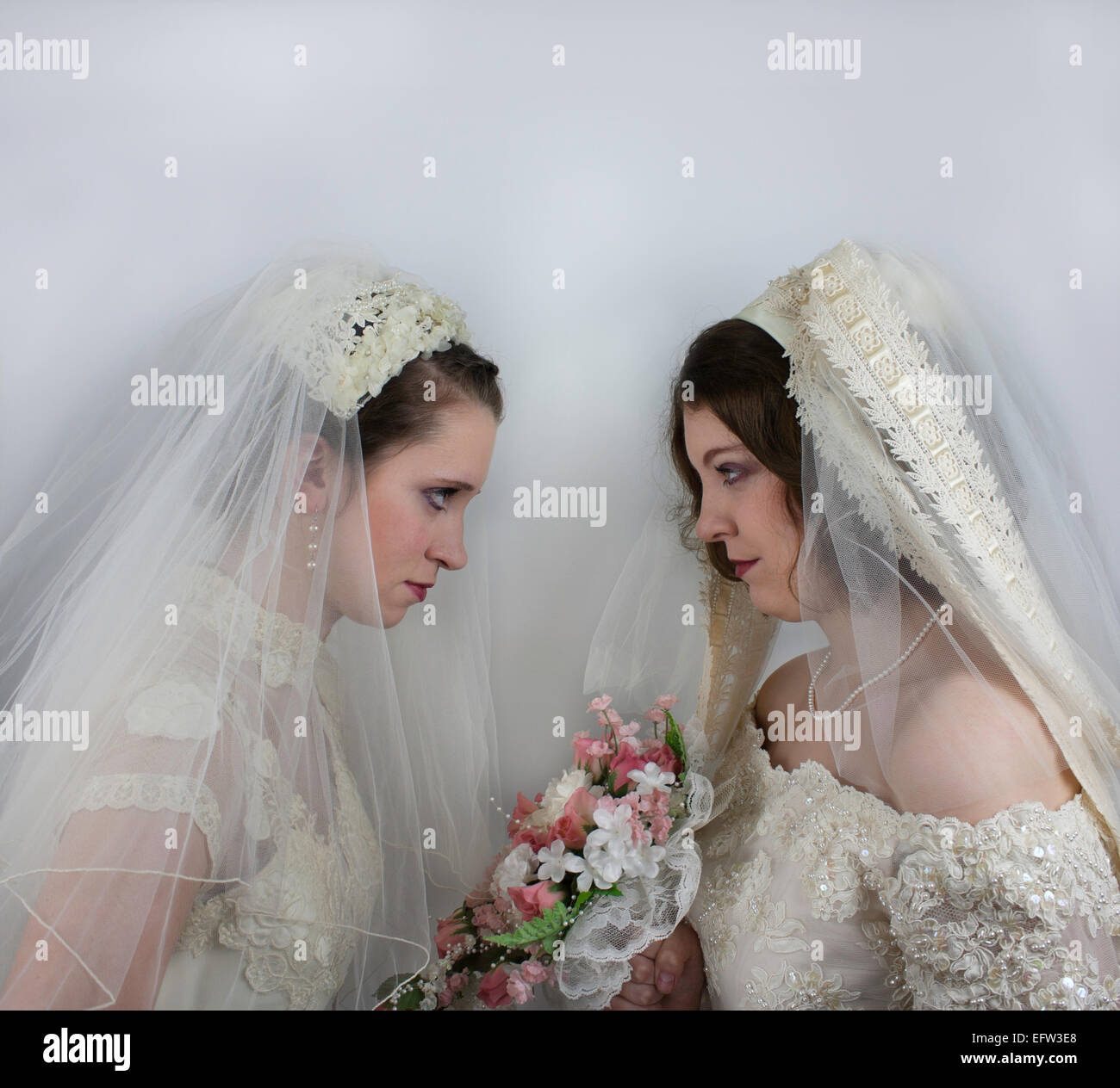 Two young brides staring at each other like bridezillas Stock Photo - Alamy