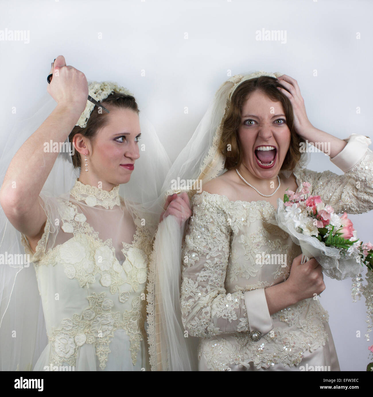 One bride has her arm raised with scissors about to tear the other ...