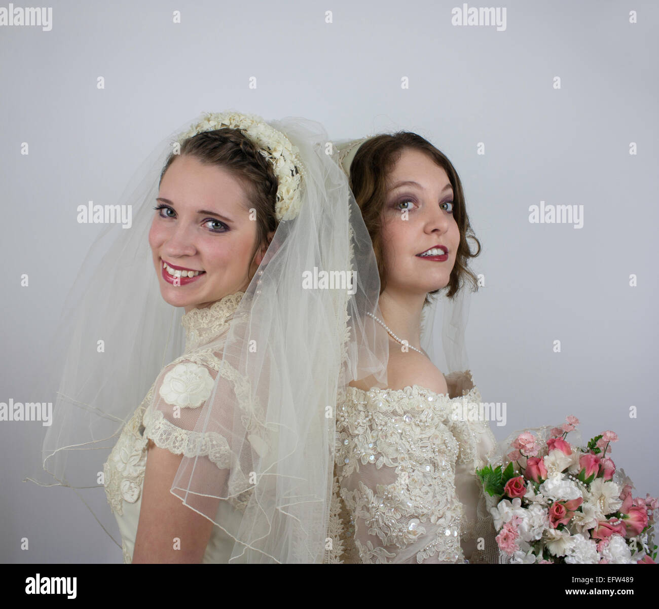 Two pretty young brides posing back to back Stock Photo - Alamy
