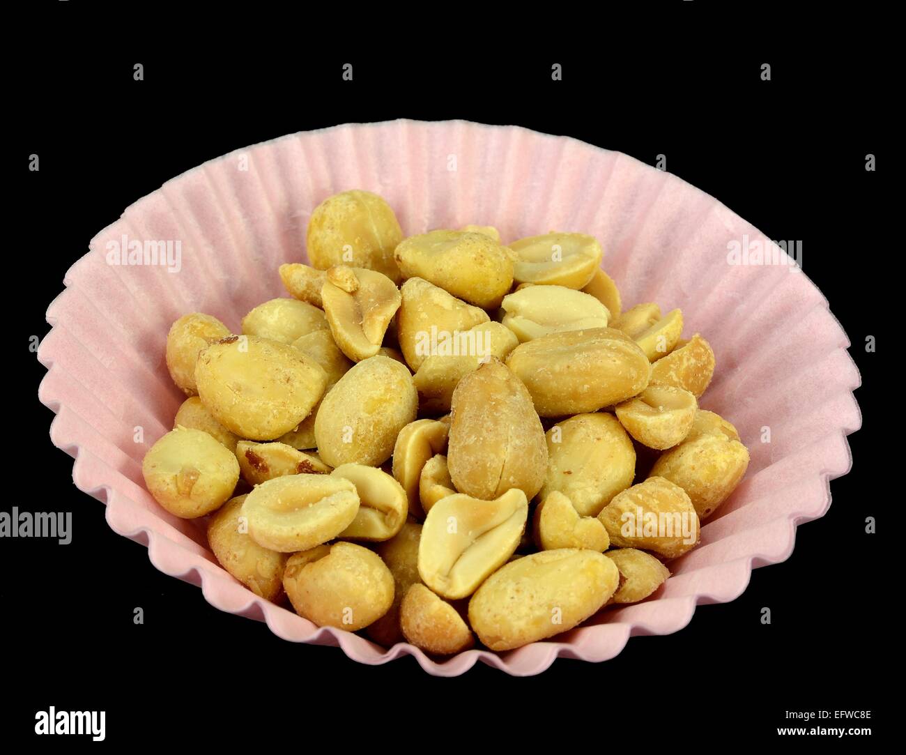Peanuts in a pink paper dish on a black background Stock Photo - Alamy