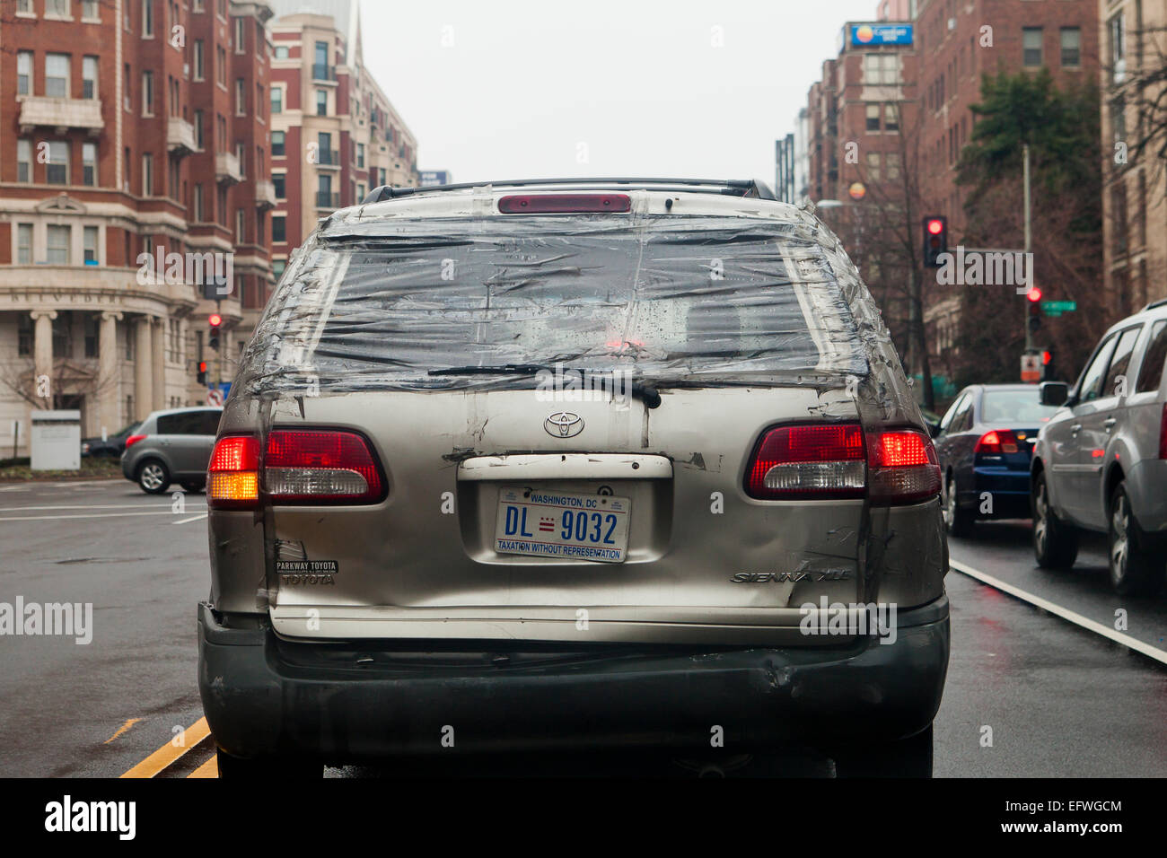 Minivan with broken rear windshield repaired with clear plastic sheet ...