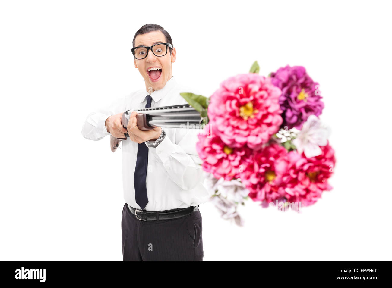 Joyful man shooting flowers from a shotgun isolated on white background ...