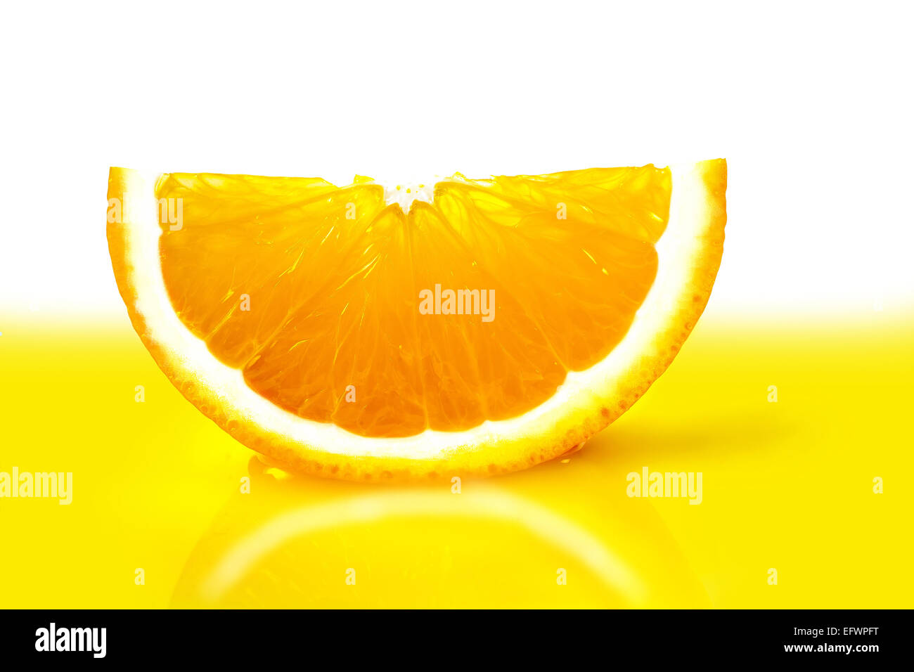 ripe orange slice close-up lying in the yellow juice Stock Photo - Alamy