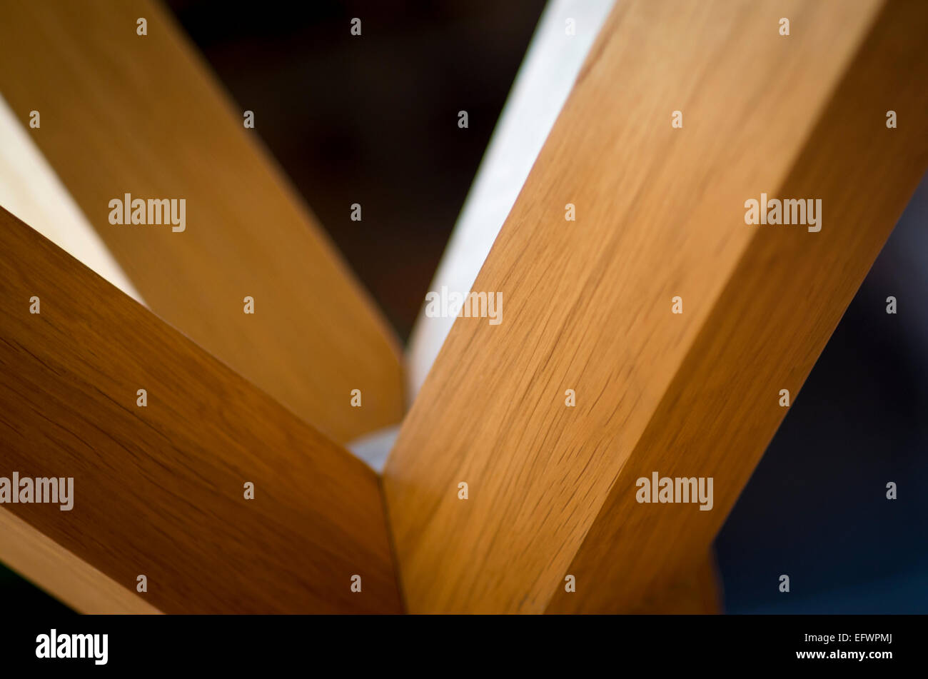 Close up of geometric oak table legs with dark background Stock Photo ...