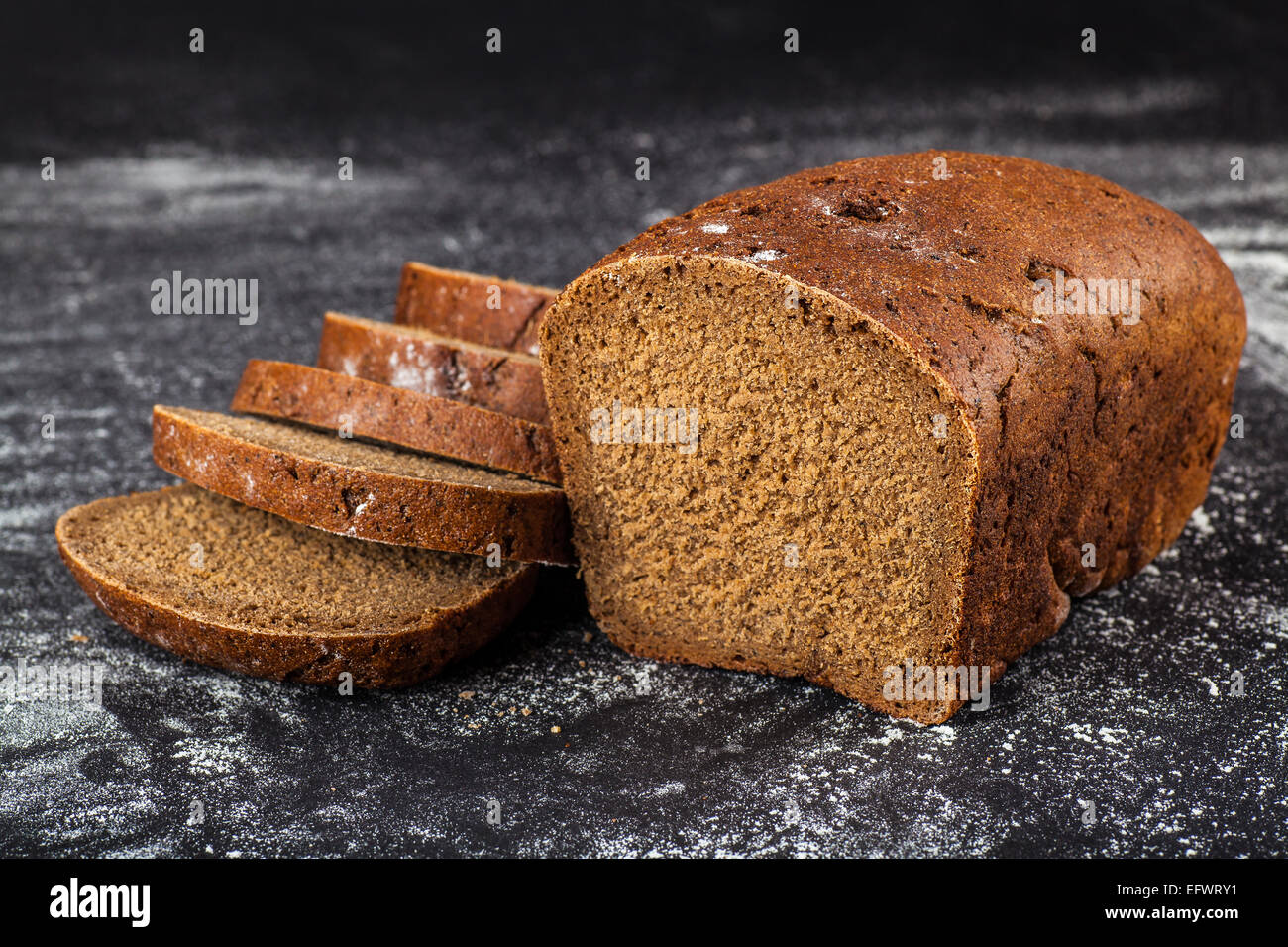 Black sliced bread on a dark background with flour Stock Photo - Alamy