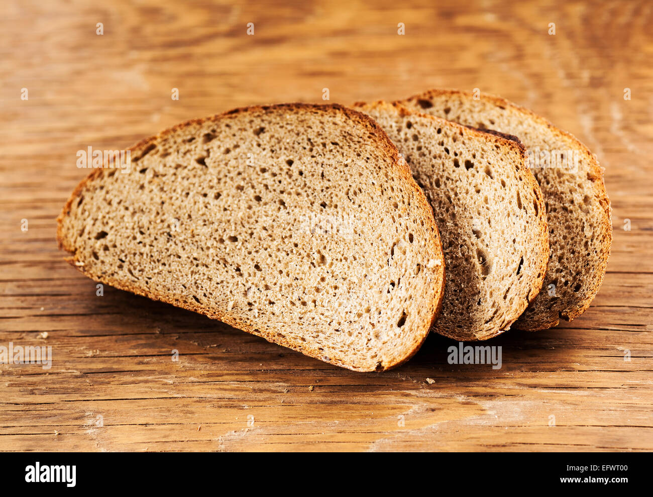 Three sliced rye bread on a wooden background Stock Photo - Alamy