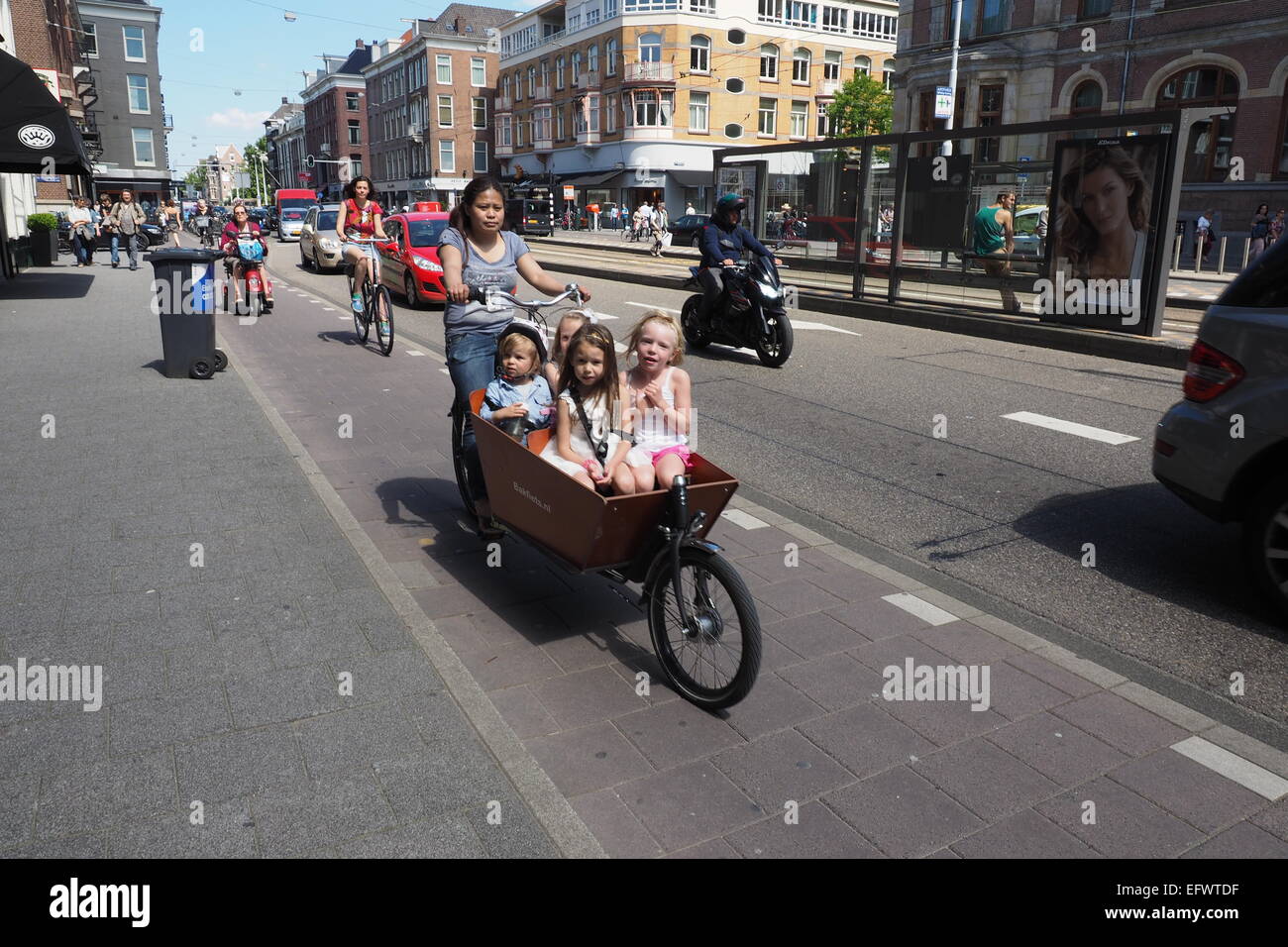 A nanny transporting children by bicycle Stock Photo - Alamy