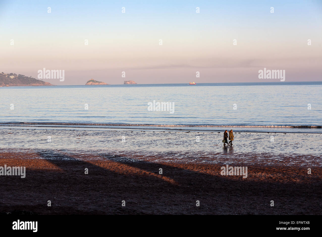 two people walking on beach at paignton,Torbay Stock Photo - Alamy