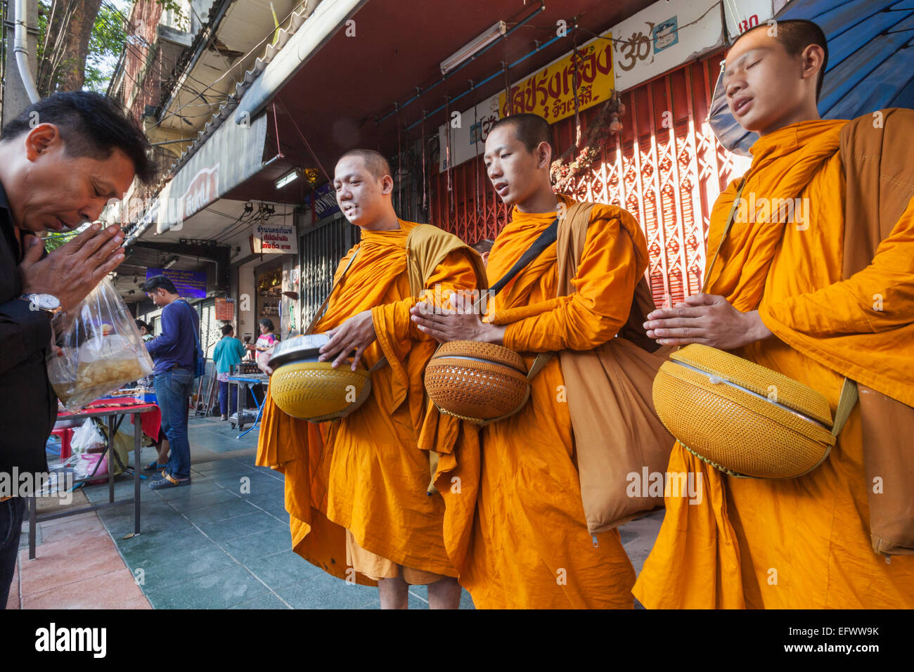 Thailand, Bangkok, Man Praying to Monks Stock Photo - Alamy
