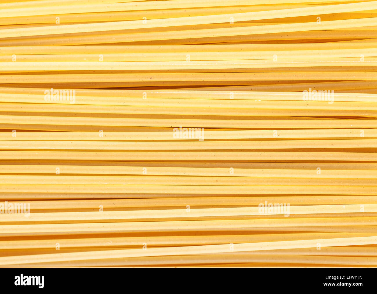 yellow background the raw pasta lying horizontally Stock Photo - Alamy