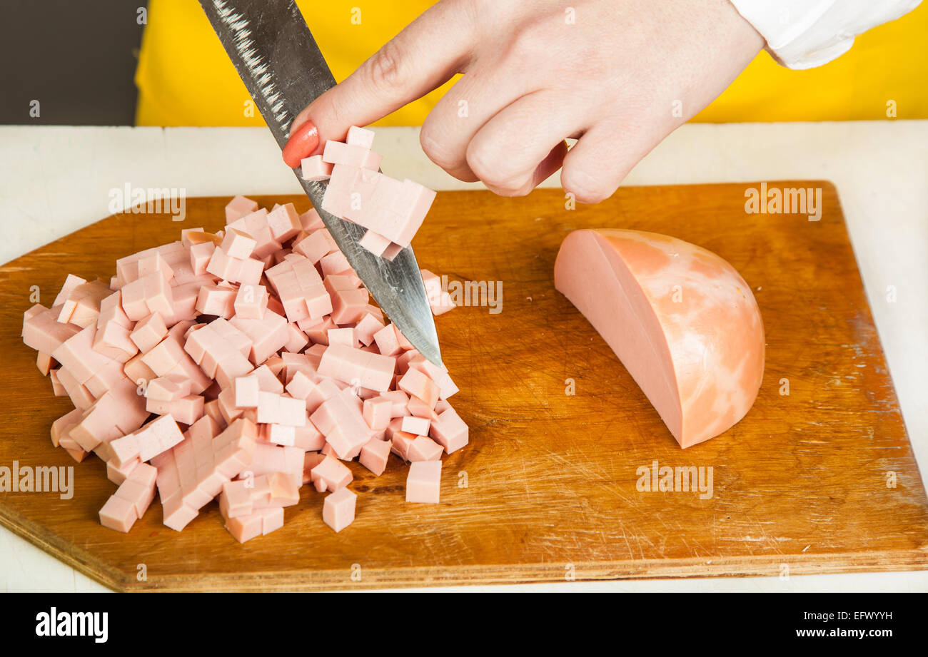 Chef woman cuts a knife sausage diced closeup Stock Photo - Alamy
