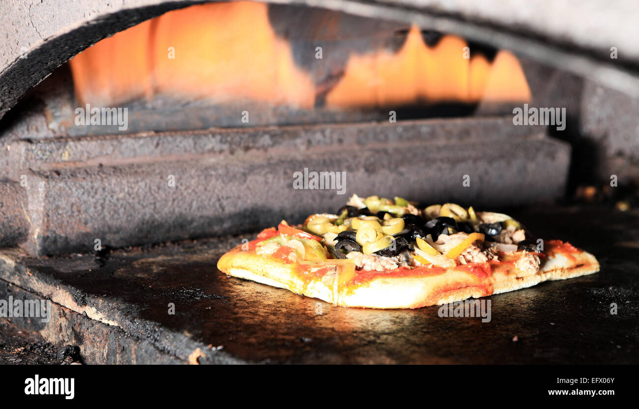 pizza is cooked in the oven over an open fire Stock Photo - Alamy