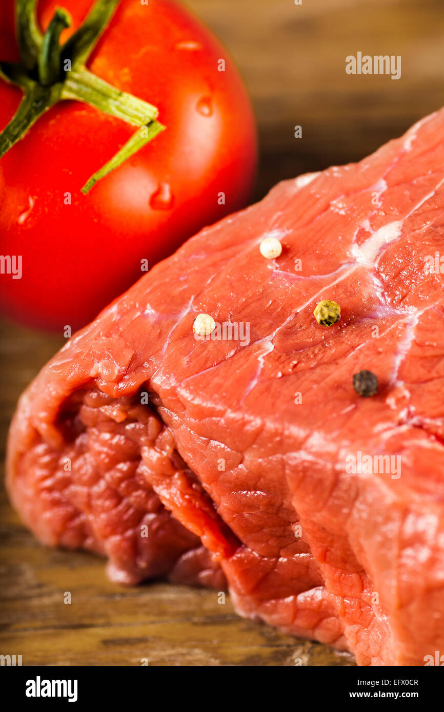 beef filet with herbs and tomato on a wooden background Stock Photo - Alamy
