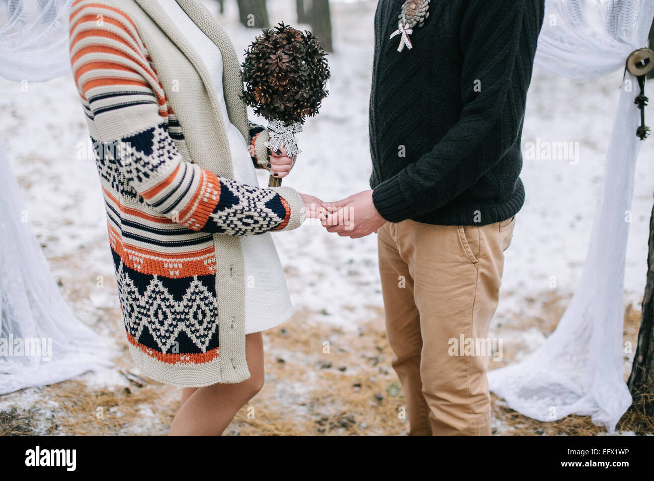 Bride and groom holding hands during the winter wedding ceremony Stock ...