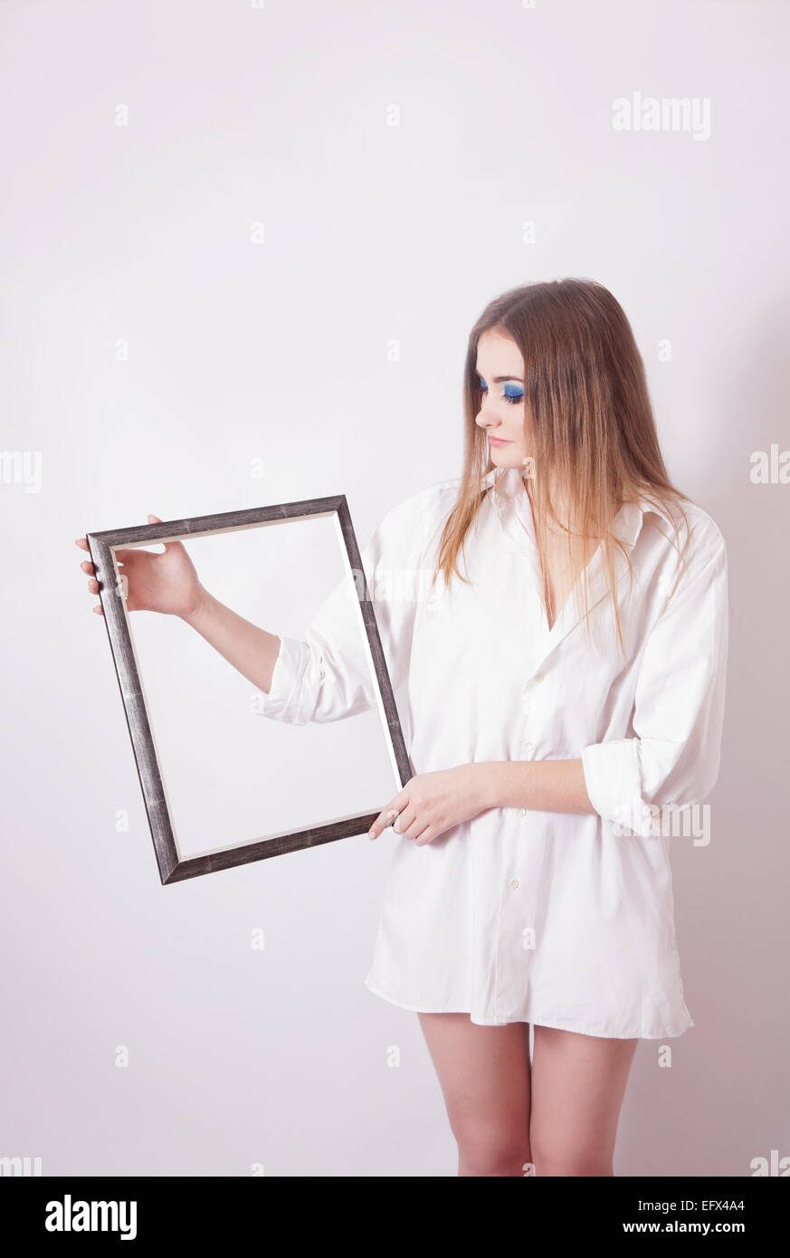 Sad beautiful girl holding a frame in his hands Stock Photo - Alamy