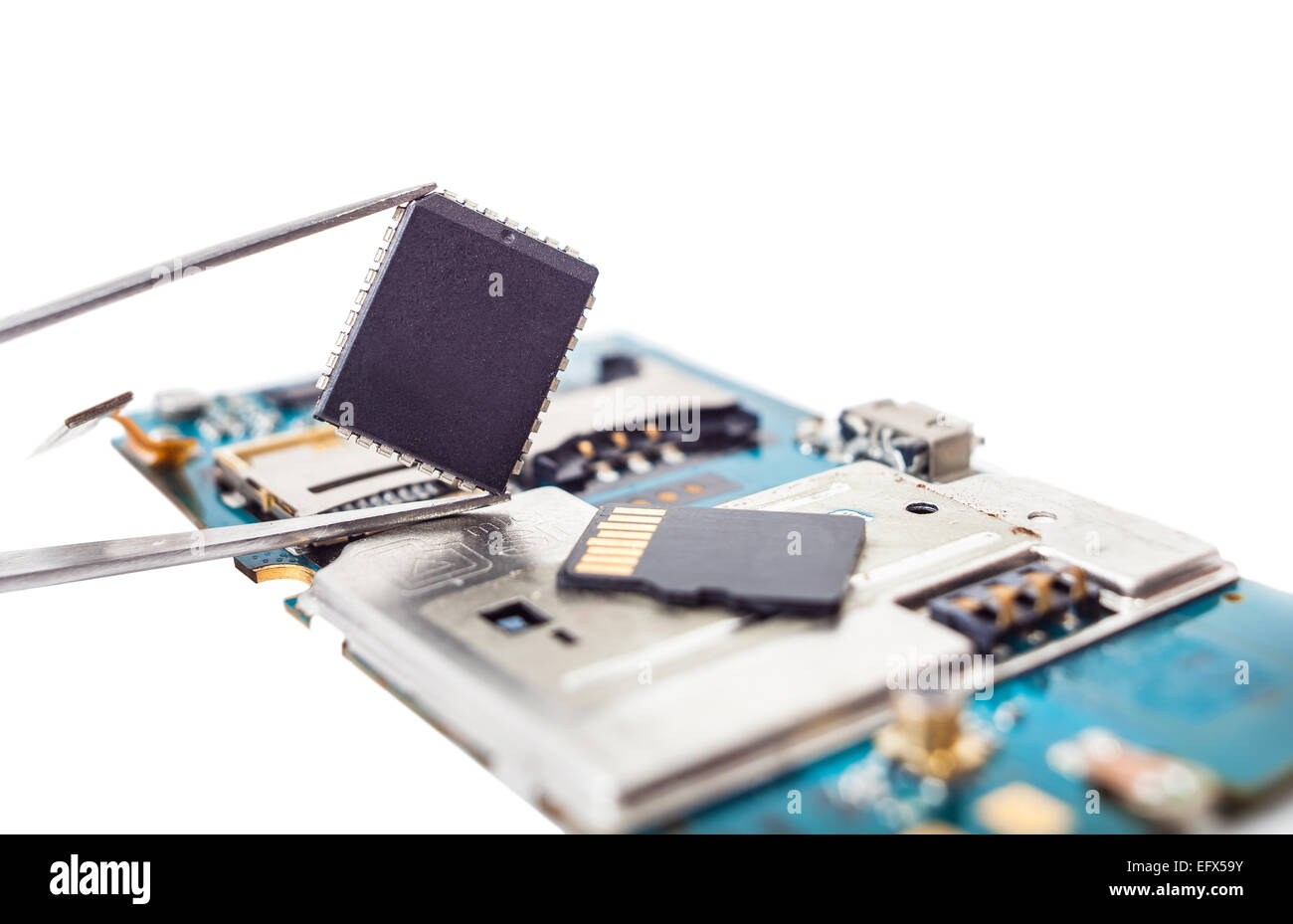 dismantle the phone and tweezers with a chip on a white isolated ...