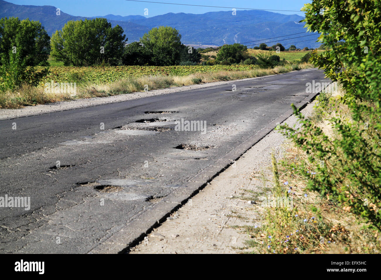 A rural road with lots of potholes Stock Photo - Alamy