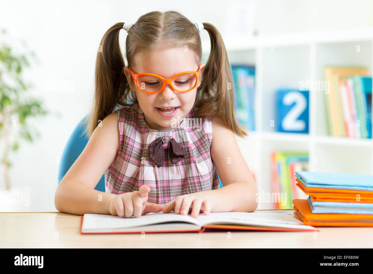 Little girl reading a book Stock Photo - Alamy