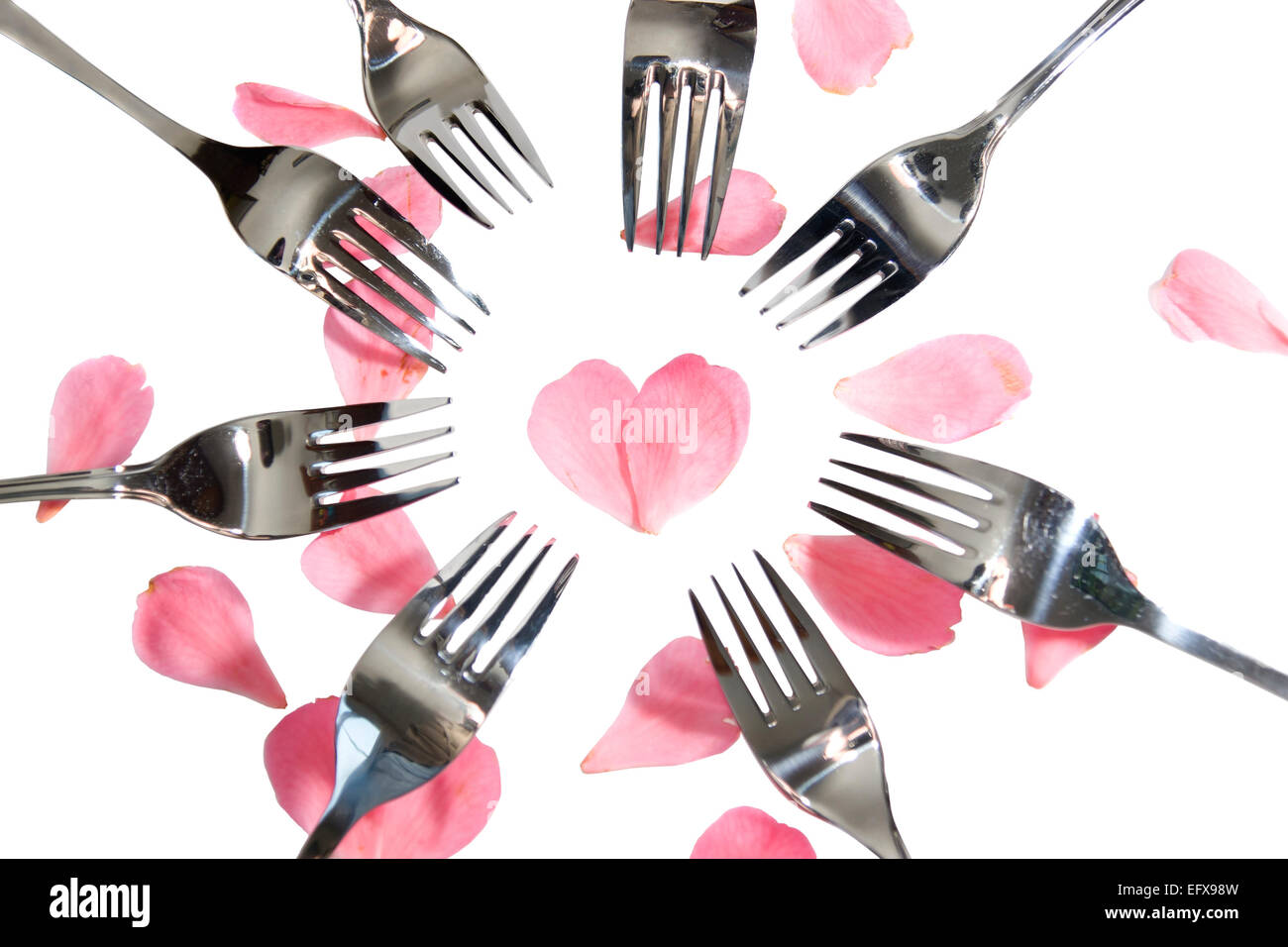 forks surrounding heart shape petal with rose petals for a concept on ...