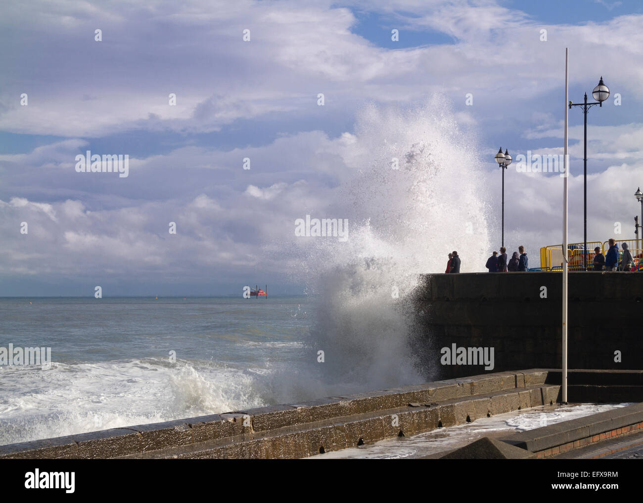 Bridlington, England, August 10th: people standing next to big waves ...