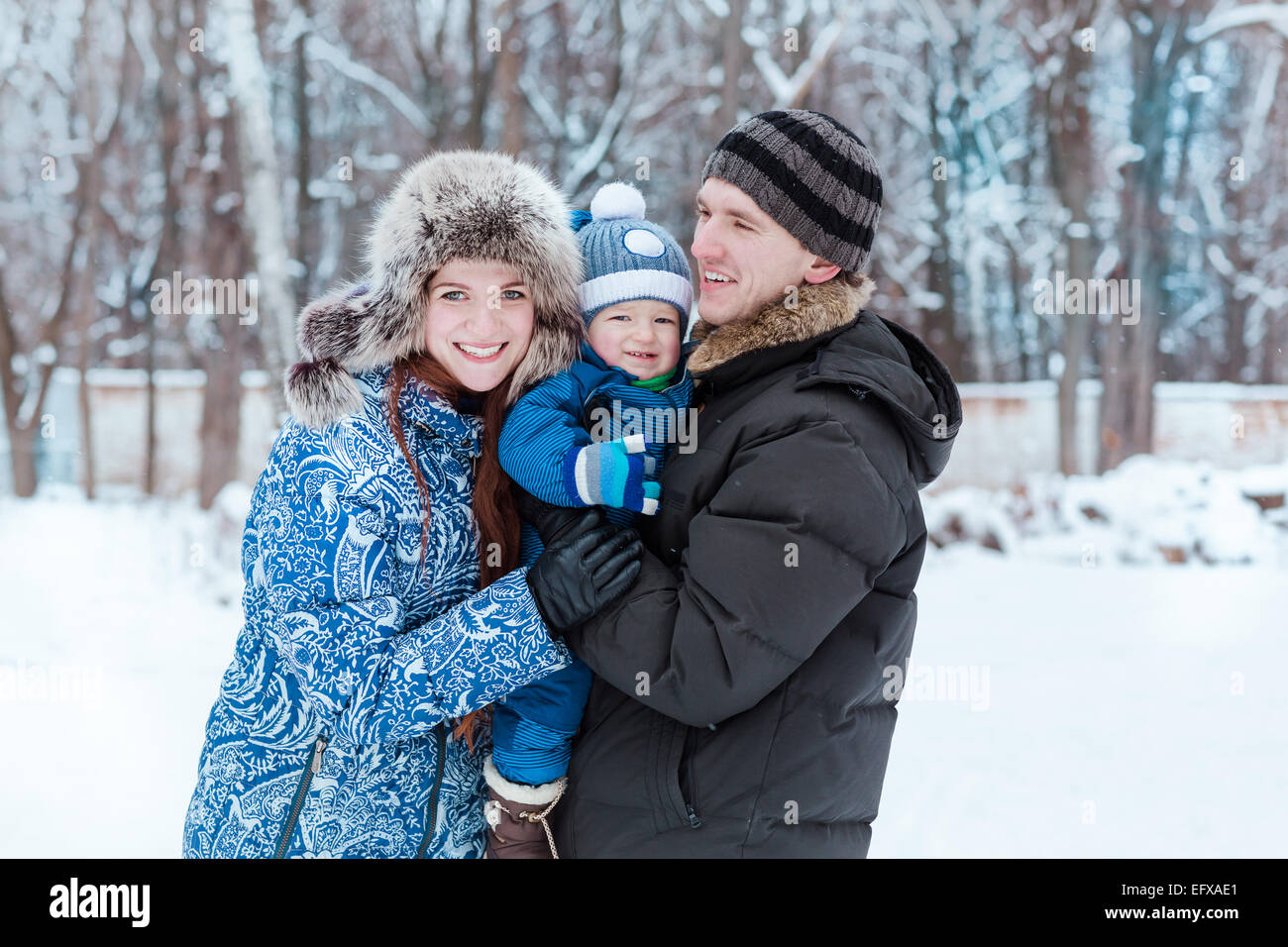 Happy family playing on snow in winter time Stock Photo - Alamy