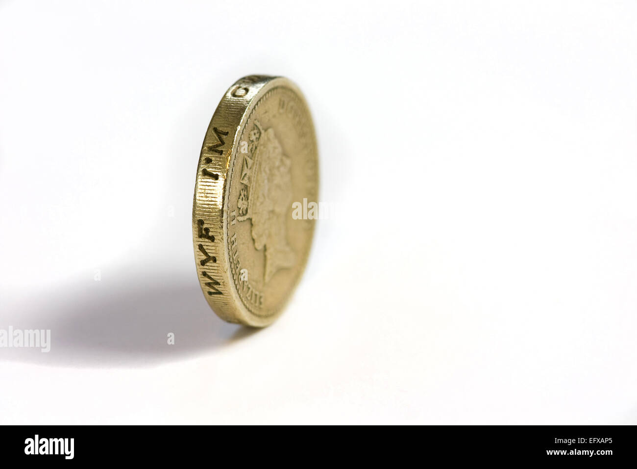 One pound coin on its edge on a white background Stock Photo - Alamy