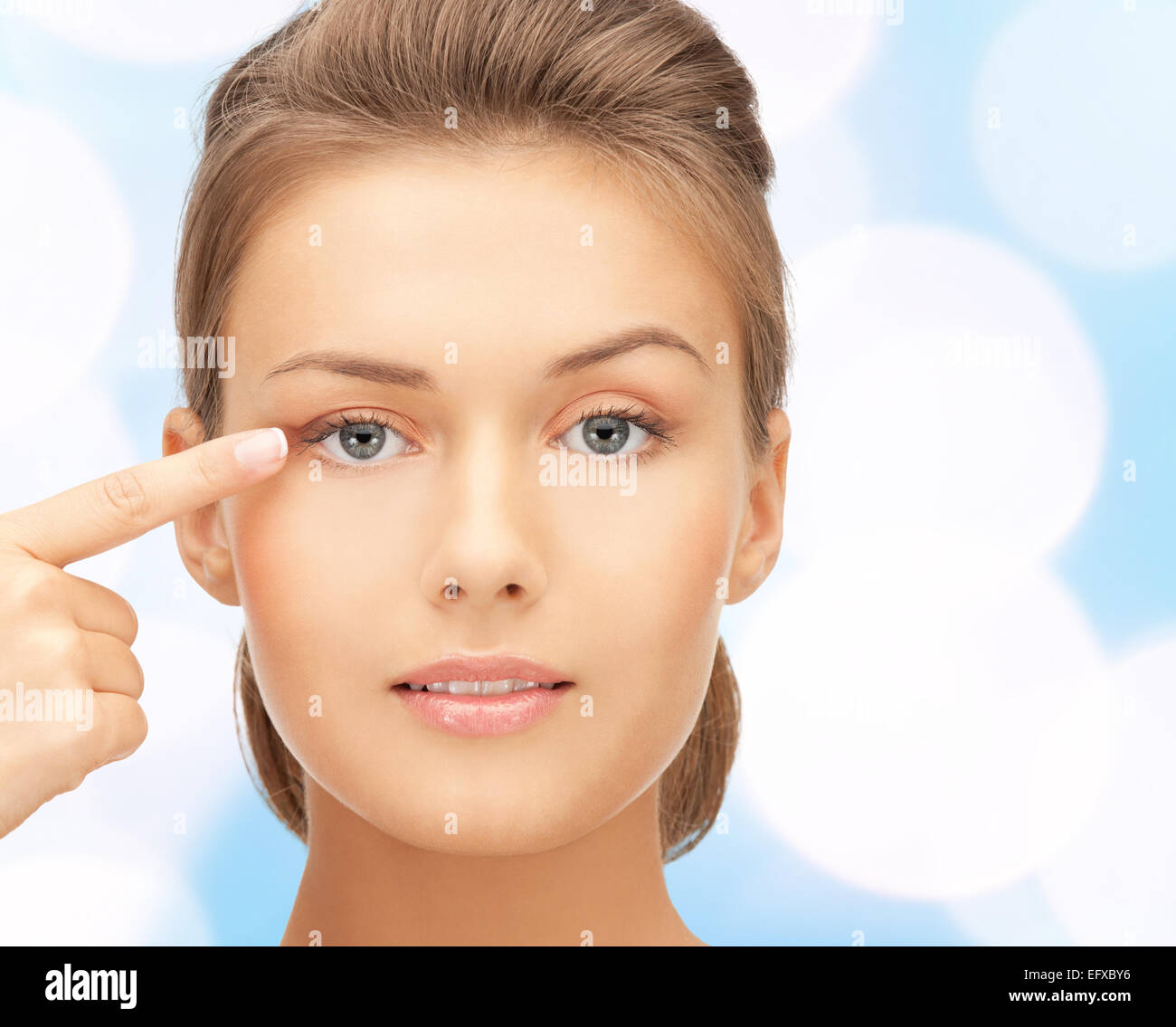 beautiful young woman pointing finger to her eye Stock Photo - Alamy