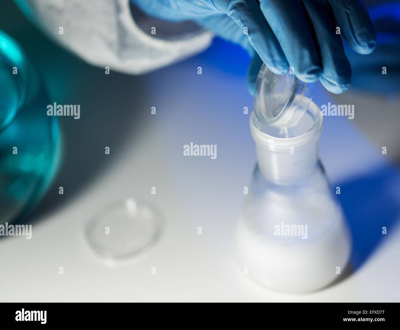 close up of hand pouring chemical into flask Stock Photo - Alamy