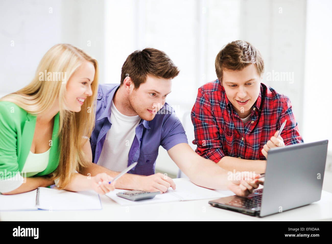 smiling students looking at laptop at school Stock Photo - Alamy