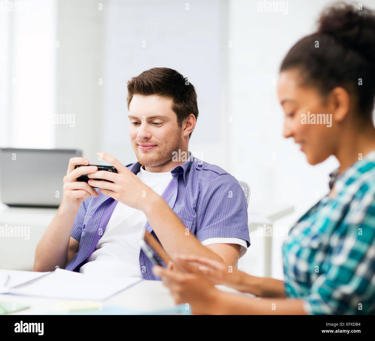 students looking at devices at school Stock Photo - Alamy